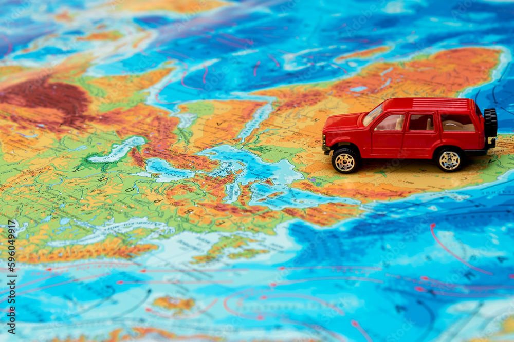 small red toy car on the physical map of the world in Africa, travel ...