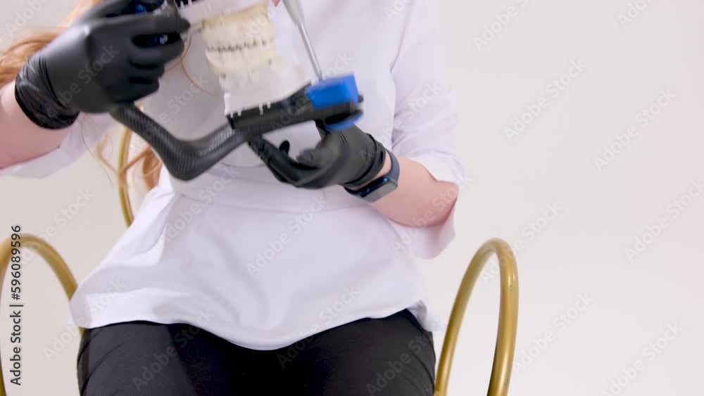 female doctor assembles articulator using screwdriver for jaw mockup ...