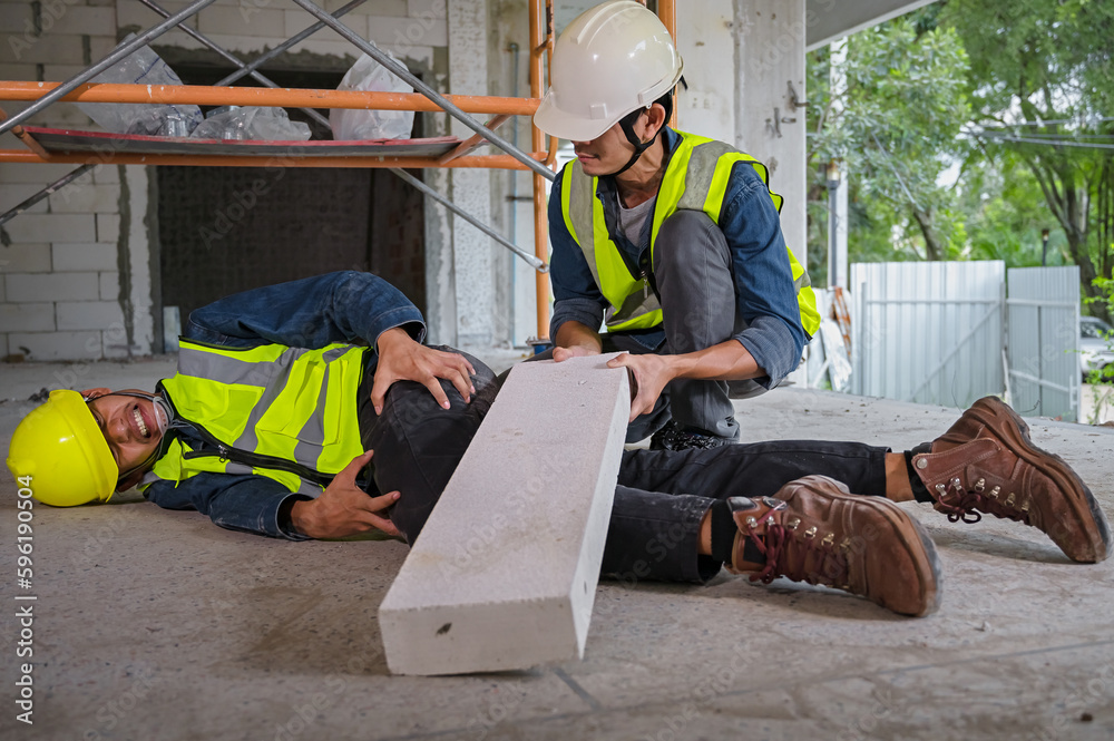 Young Asian builder falls from a height at a construction site. An ...