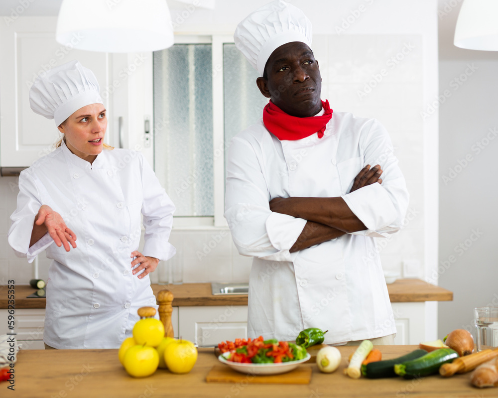 Strict female chef reprimanding male colleague in private kitchen Stock Photo | Adobe Stock