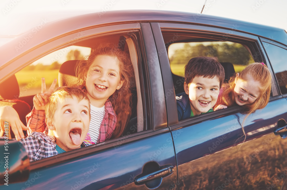 Group of cute children sitting in the car and and looking out through ...