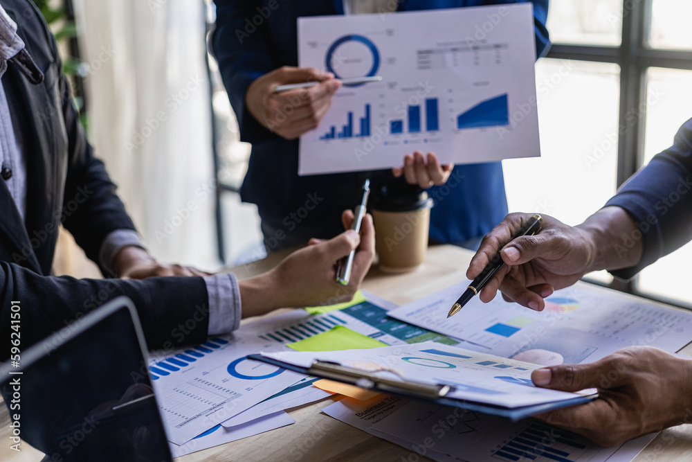 Business teams review documents, graphs, charts and financial reports ...