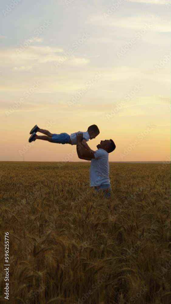 Vertical Screen: Slow motion dad throwing little boy up in the air in ...