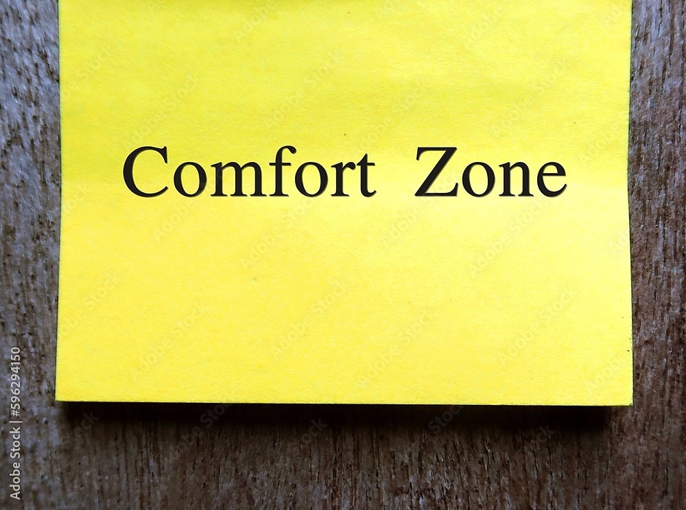 Yellow note on copy space gray wall with text handwritten COMFORT ZONE ...