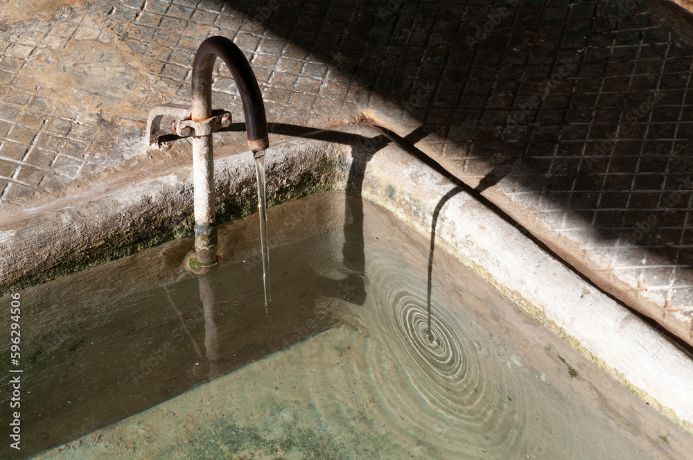 Un chorro de agua fluye hacia la pila de una fuente. Stock Photo ...