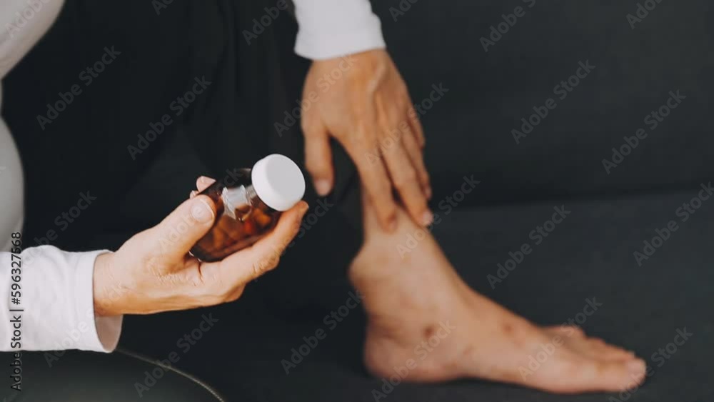 Man's hands holds a blue capsule and glass of water over the table ...