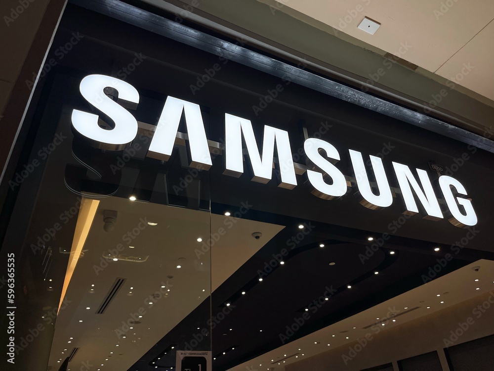 Glowing Samsung logo on facade of store. Close-up view. Ceiling with ...