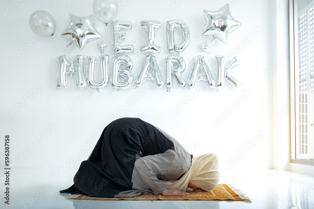 Muslim woman wears hijab bows down on prayer mat to pray Allah on floor ...