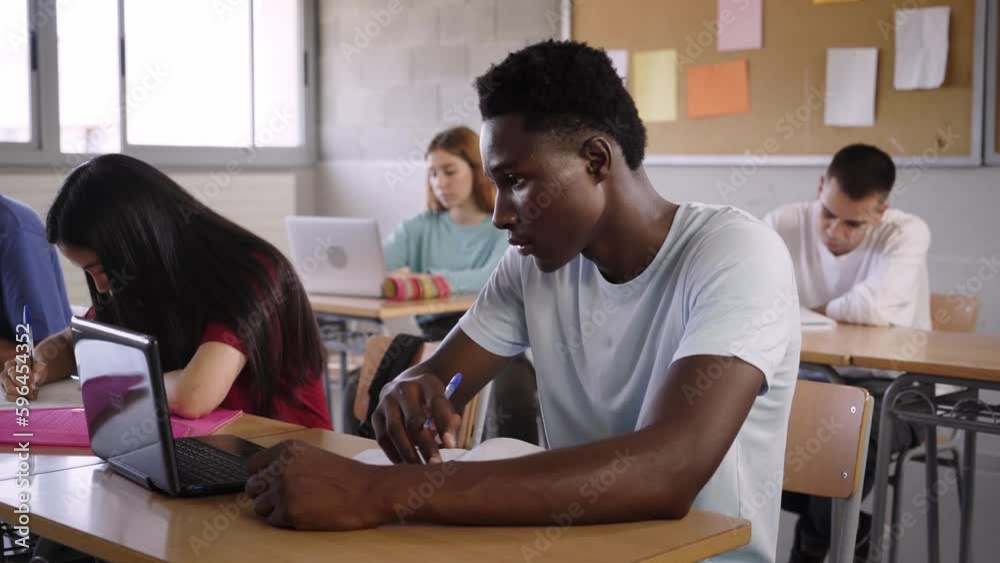 Young African American student taking hand written lesson notes in ...