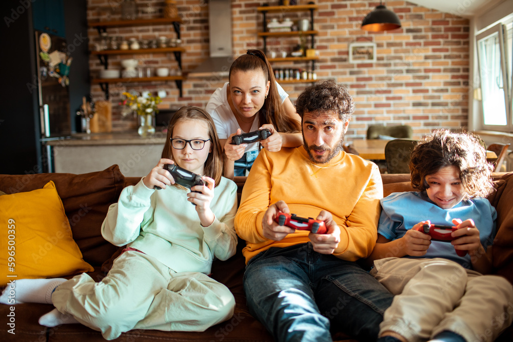 Young family playing video games together in the living room on a ...