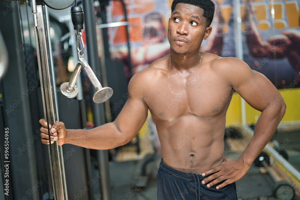 A handsome African male builds strength and vitality in a gym, training ...