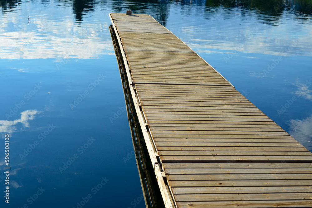 An old wooden boat pier or floating dock with a yellow color mooring ...