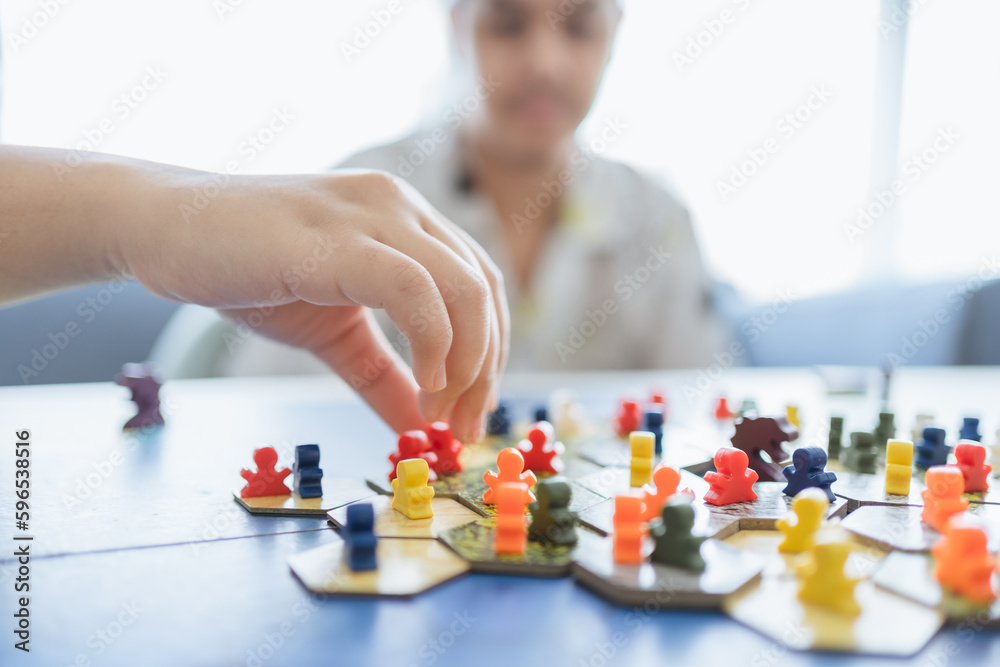 Board game playing concept. People hands hold meeple figures for ...