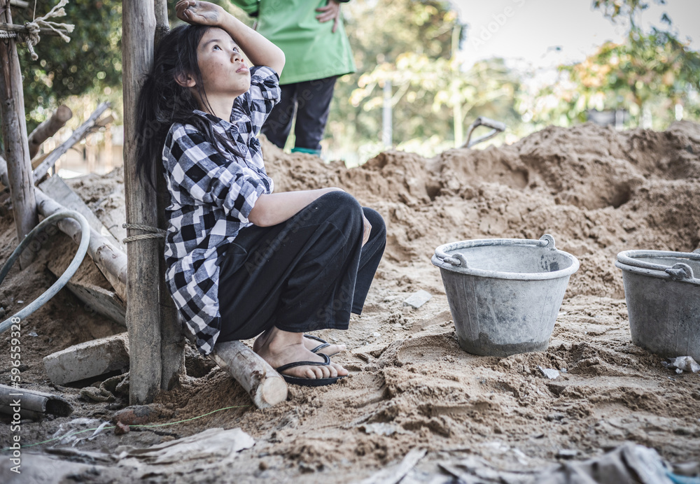 Exhausted little girl sitting construction background. child labor and ...