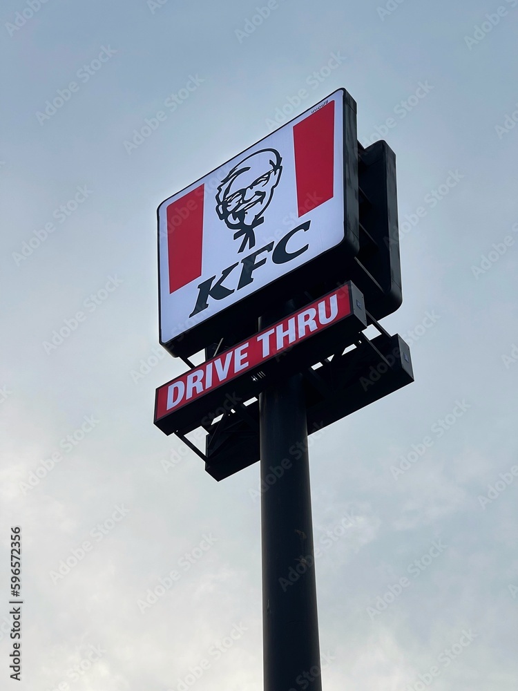 KFC light box rises against dark sky background. Clouds are gathering ...