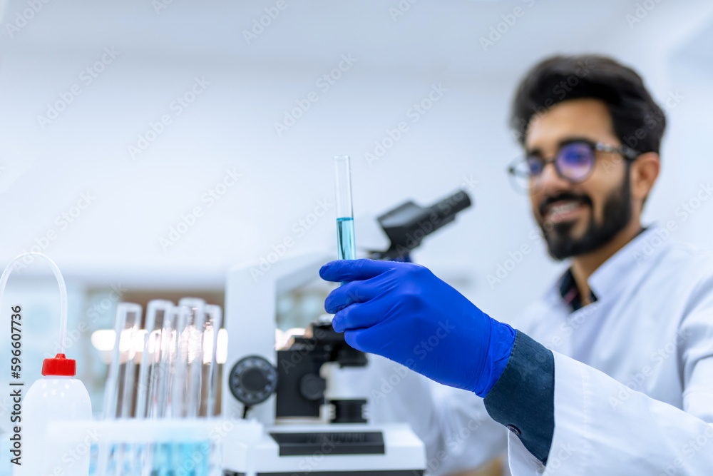Smiling doctor working in modern laboratory research scientist examines ...