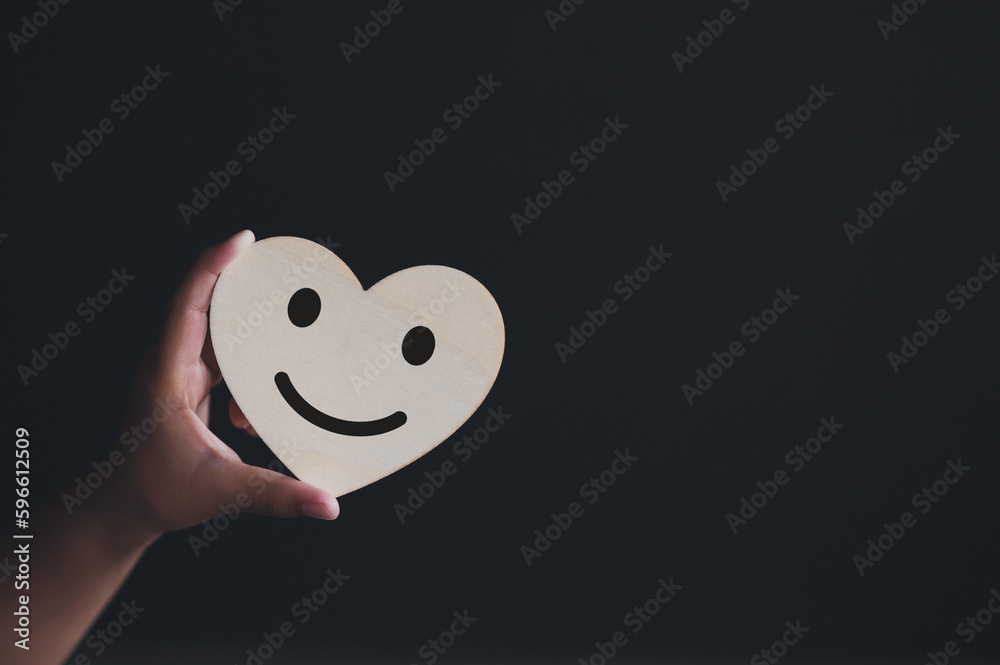 Heart shaped wooden sign in child's hand, happy, smiling, relaxed face ...