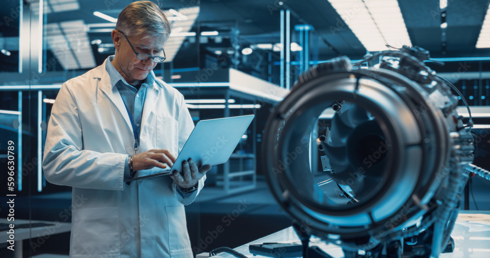 Foto de Professional Adult Engineer Using a Laptop Computer, Analyzing ...