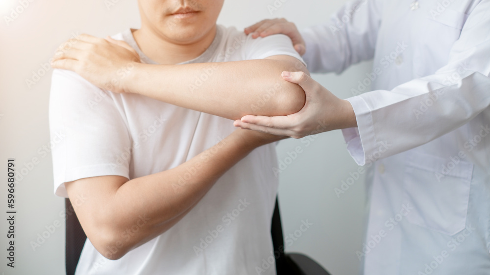 Therapist treating a male injured by shoulder impingement test ...