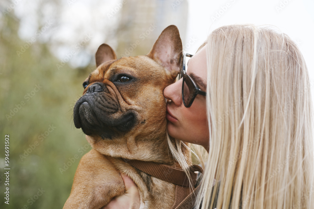 Beautiful young woman kissing her dog. Loving owner giving her pet a ...