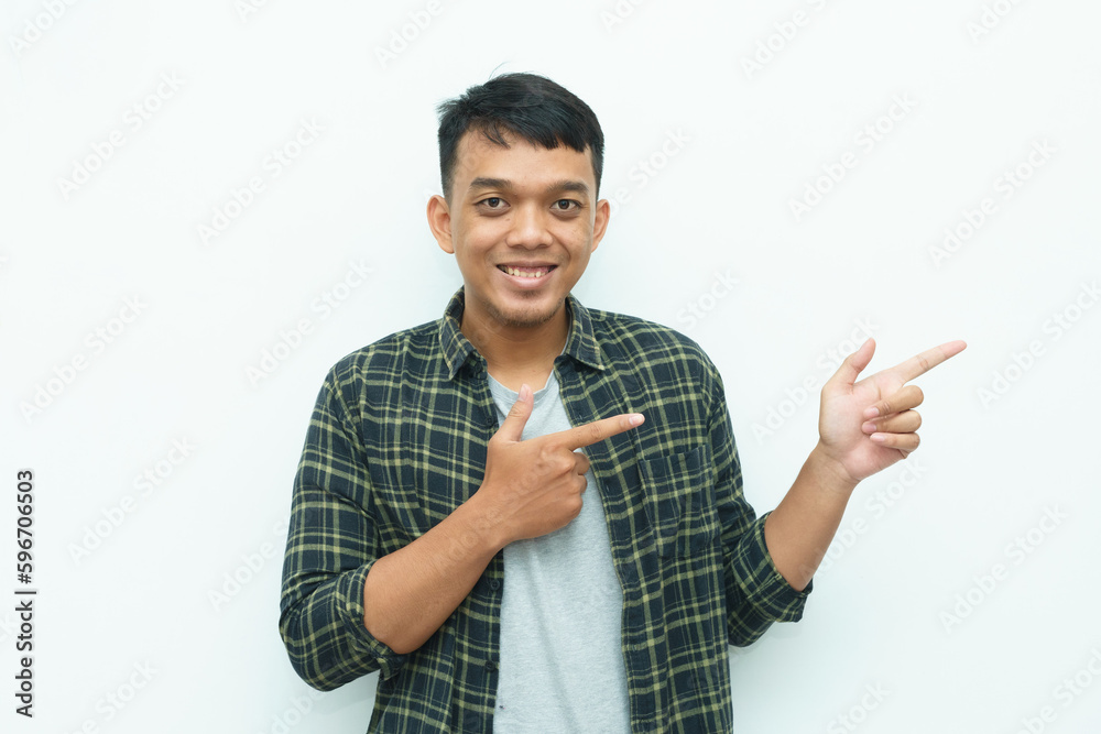 Young Asian man smiling and the finger pointing to the left side with ...