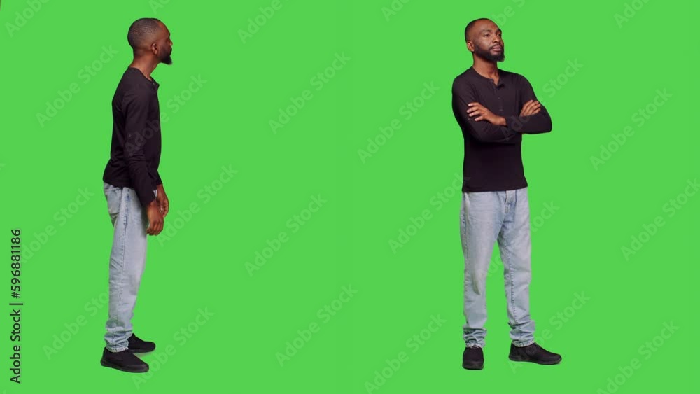 Confident joyful man posing in front of studio camera, smiling and ...