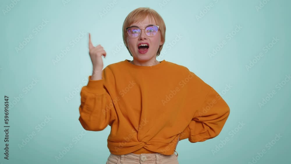 Eureka. Inspired young woman pointing finger up with open mouth, having ...