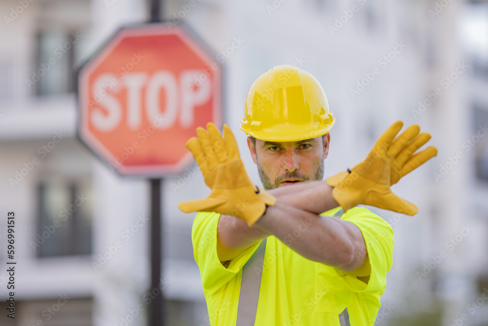 Worker builder with stop road sign. Man in hardhat helmet doing stop ...