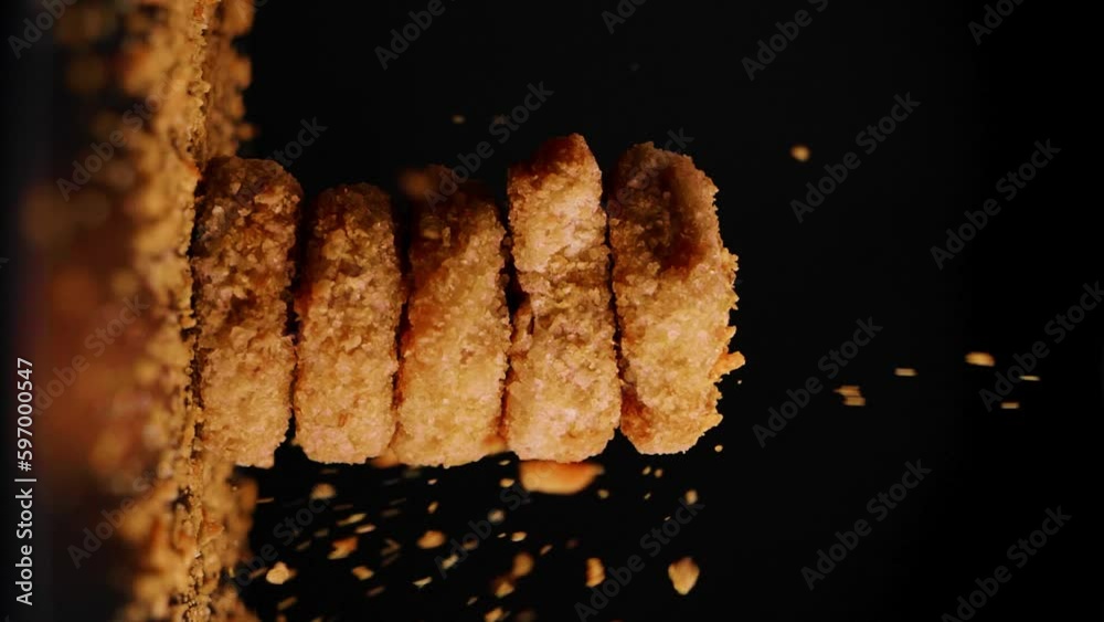 Vertical Shot of Spinning vegan chicken nuggets with falling crumbs in ...