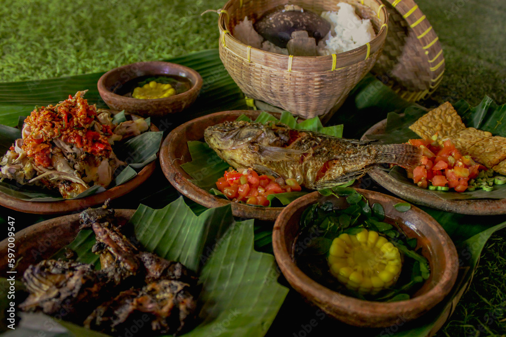 Traditional sasak dish consisting of ayam merangkat, fried tilapia ...