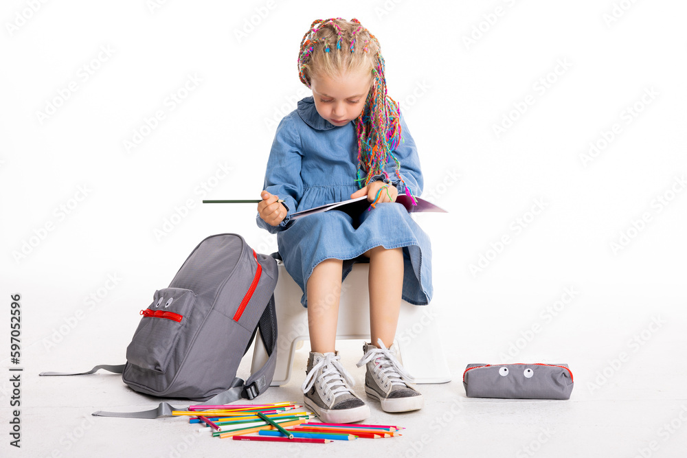 Serious concentrated girl sitting on white background in studio ...