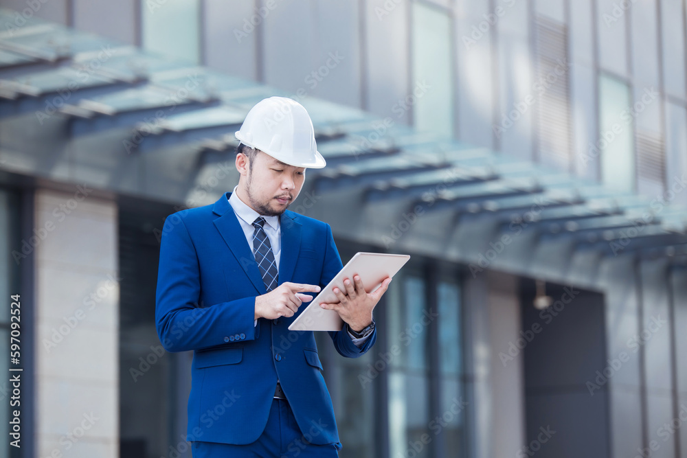 Handsome engineer wearing suit and hard hat or white helmet on building ...