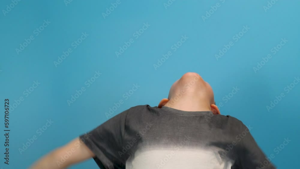 portrait of an angry little boy with a furious expression on a blue ...