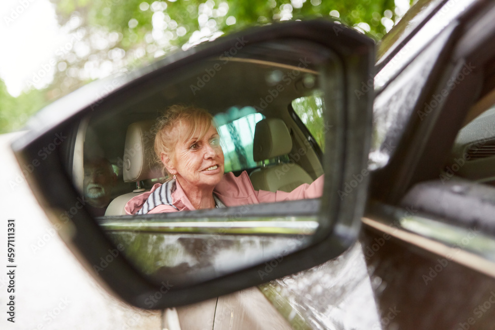 Senior woman on side-view mirror while driving car in nature Stock ...