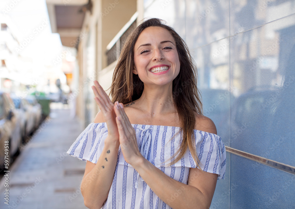 pretty woman feeling happy and successful, smiling and clapping hands ...