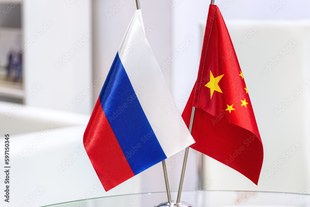 Russian and Chinese flags on glass table in meeting room. The concept ...