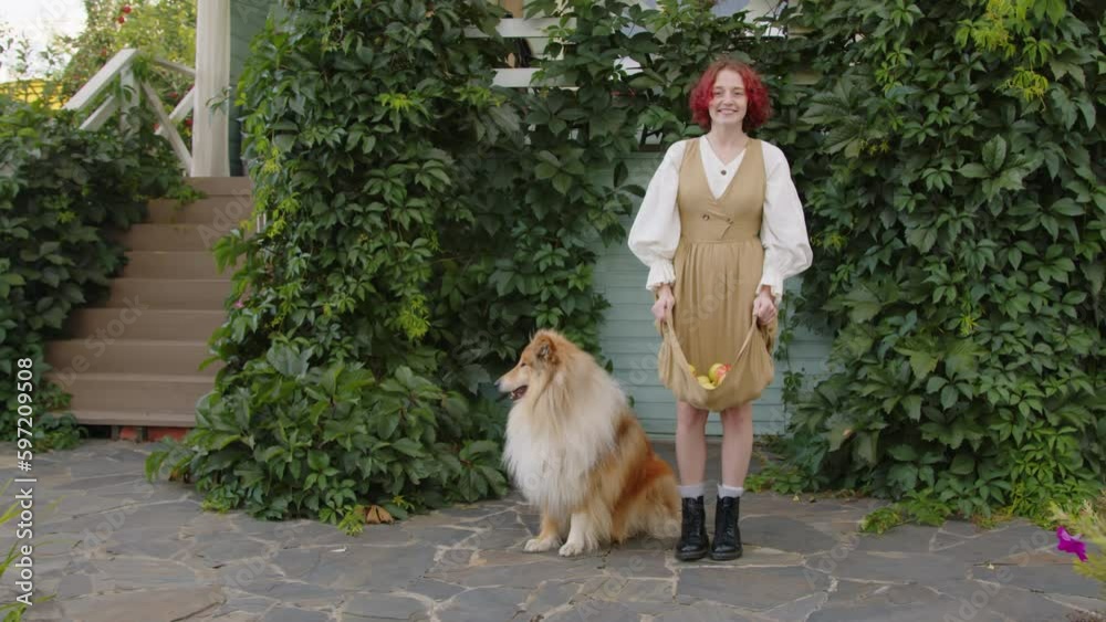 Long shot of joyful gen Z girl wearing vintage outfit holding apples in ...