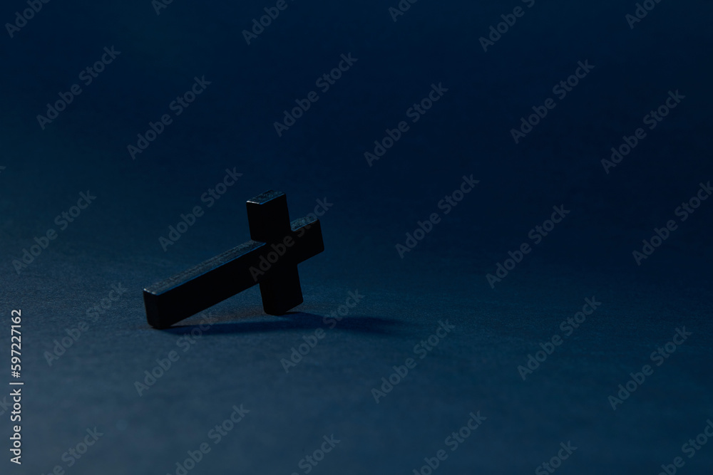 Poster Black wooden traditional cross fallen down and lying on edge at ...