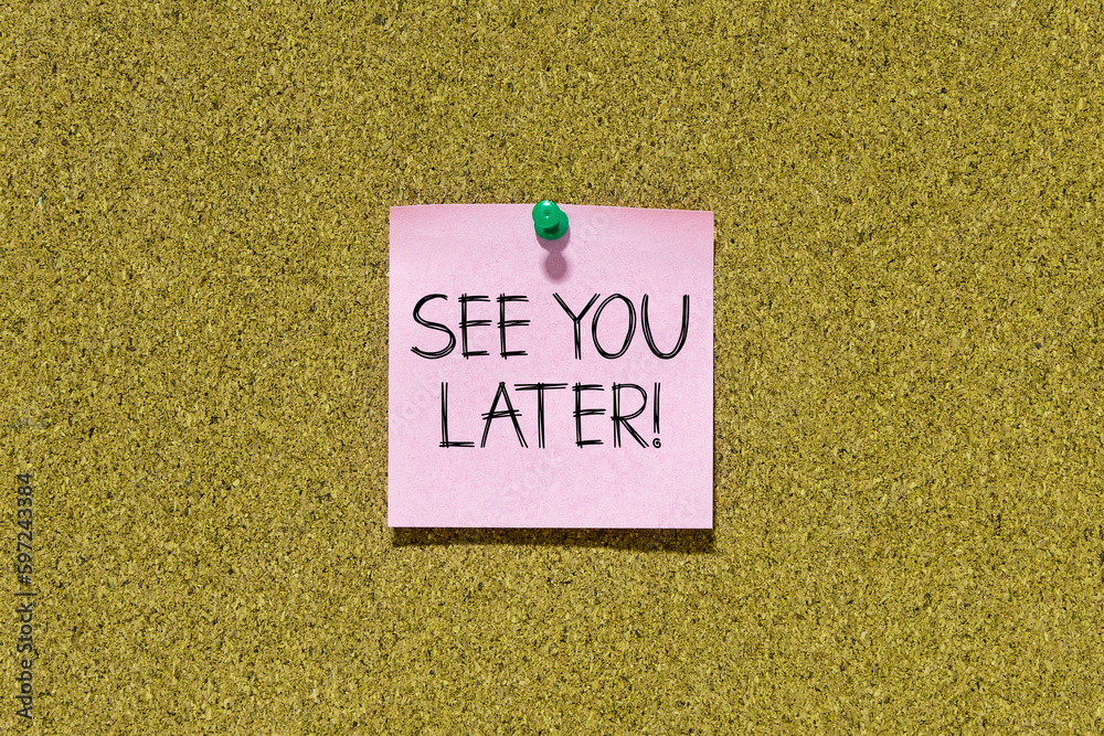See you later text on pink post-it paper pinned on bulletin cork board ...