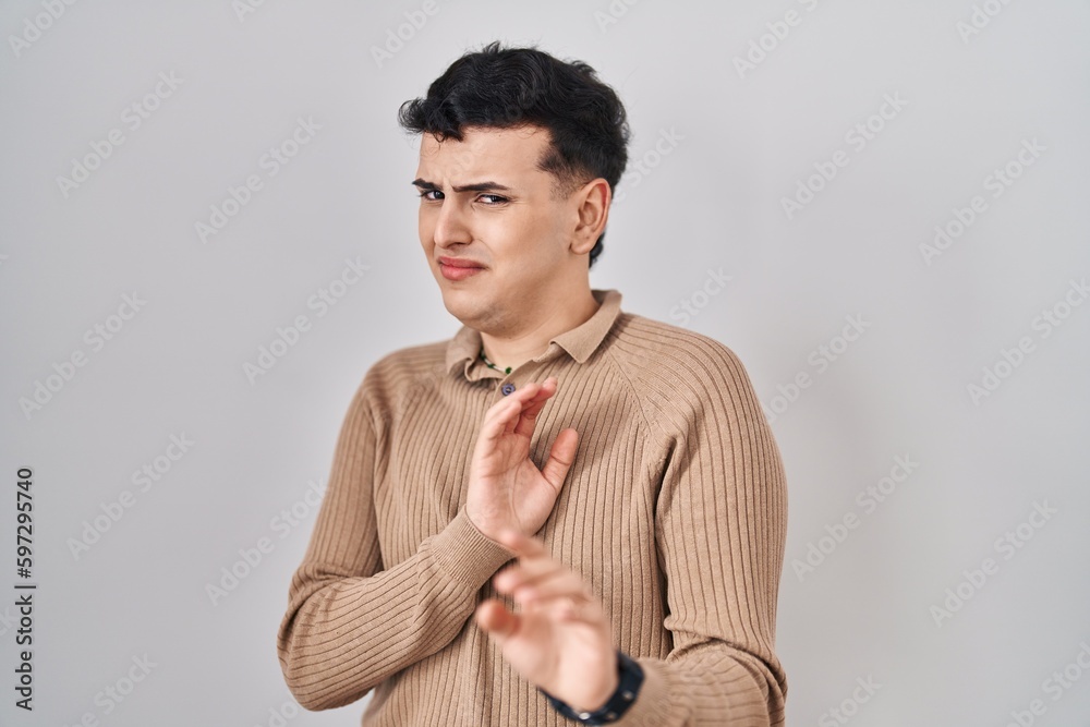 Non binary person standing over isolated background disgusted ...