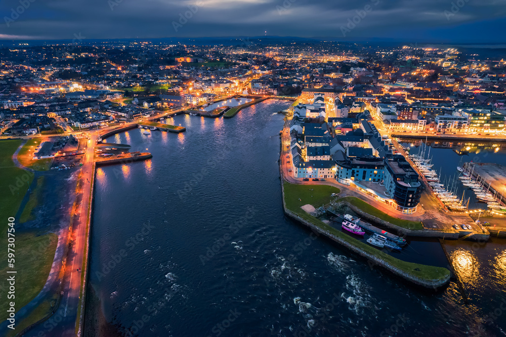 Illuminated port town at night. Aerial view on River Corrib and Galway ...