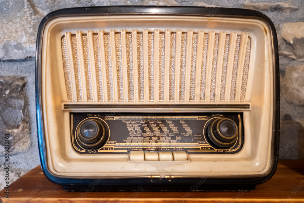 an old radio on a shelf on a stone background with volume, tone and ...