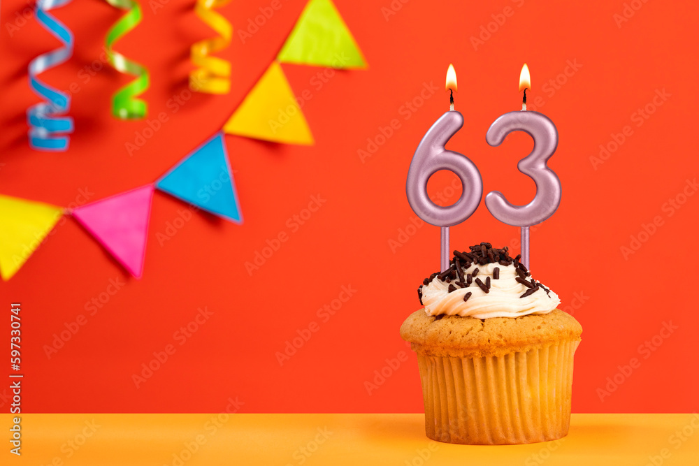 Birthday cake with number 63 candle - Sparkling orange background with ...