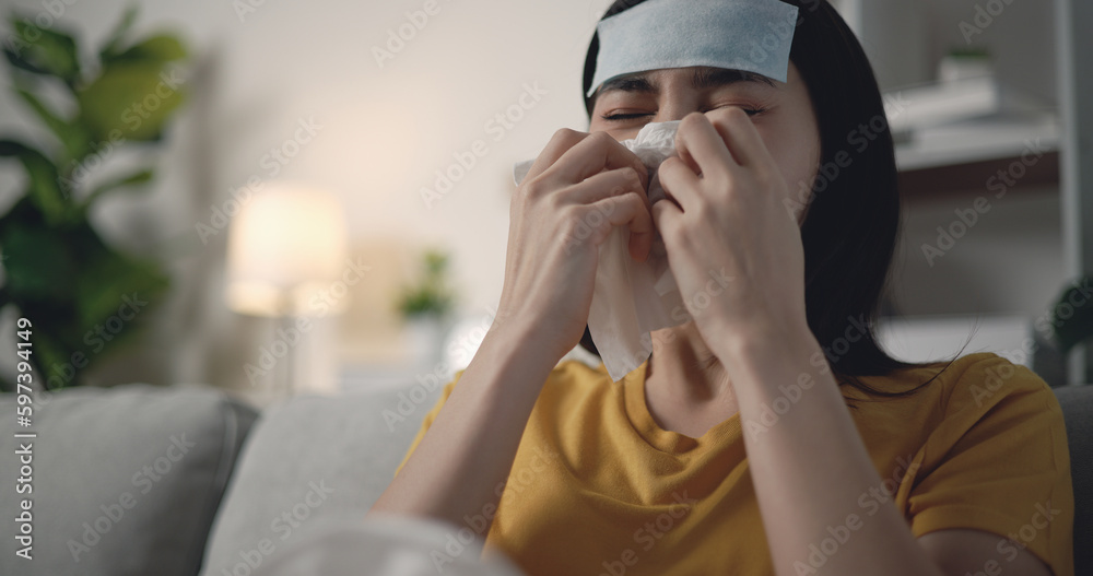 Foto de Young Asian woman suffering from flu with a fever-reducing ...