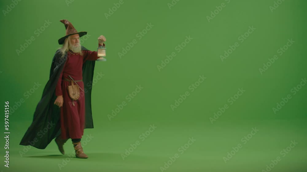 Green Screen. A Smiling Wizard in a Magic Hat and Cloak Walks With a ...