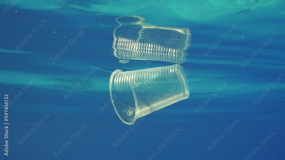 Close-up of transparent disposable acrylic glass floats under water ...
