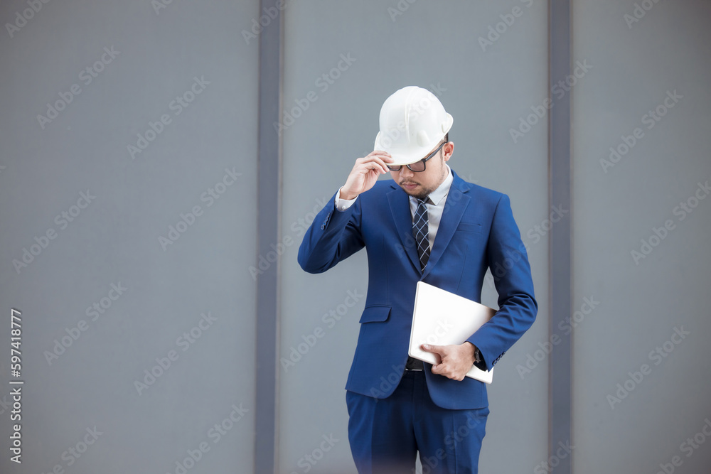 Handsome engineer wearing suit and hard hat or white helmet on building ...