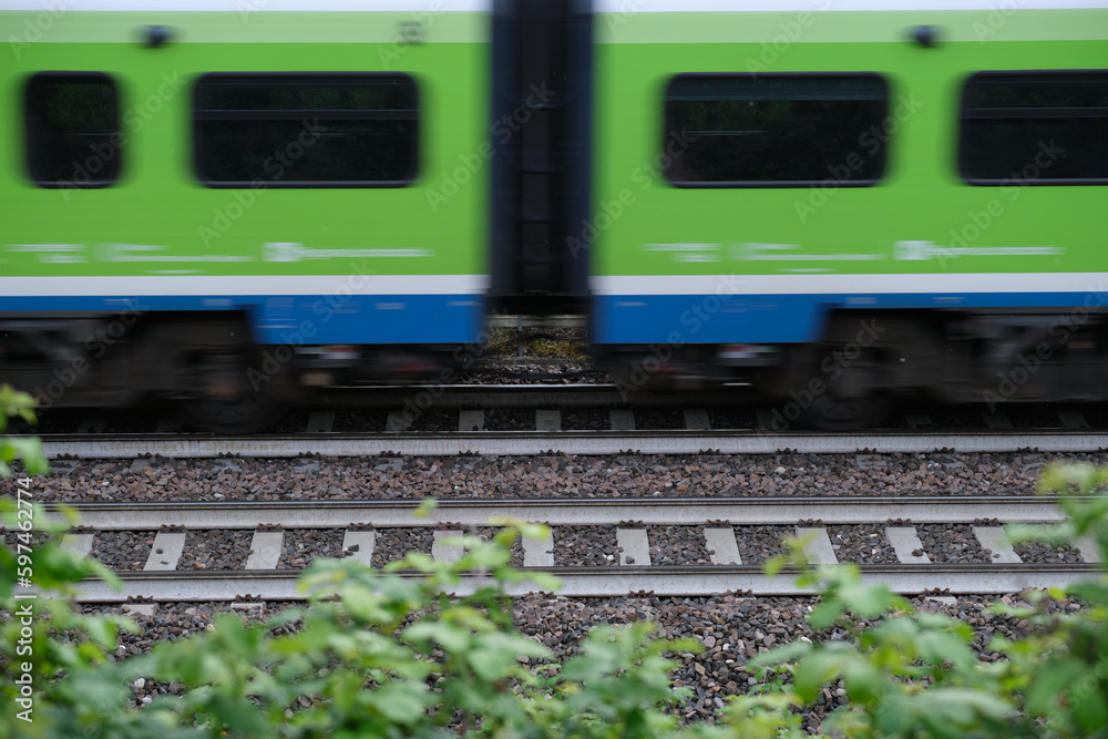 High speed train blurred side view. White green train fast moving side ...