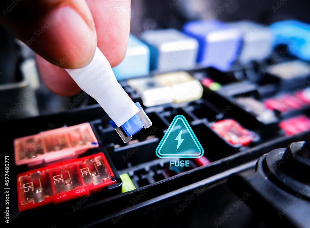 Close up of mini fuse for electric car system with a voltage caution ...