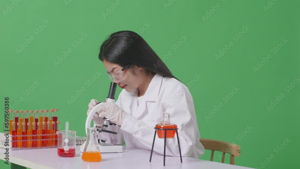 Side View Of Asian Woman Scientist Looking At The Orange Liquid In The ...